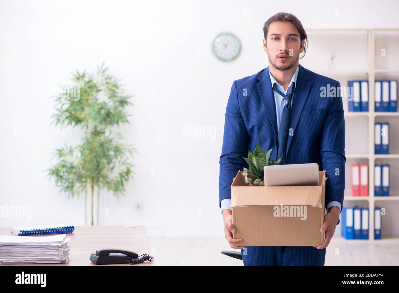 Young man being fired from his workplace Stock Photo - Alamy