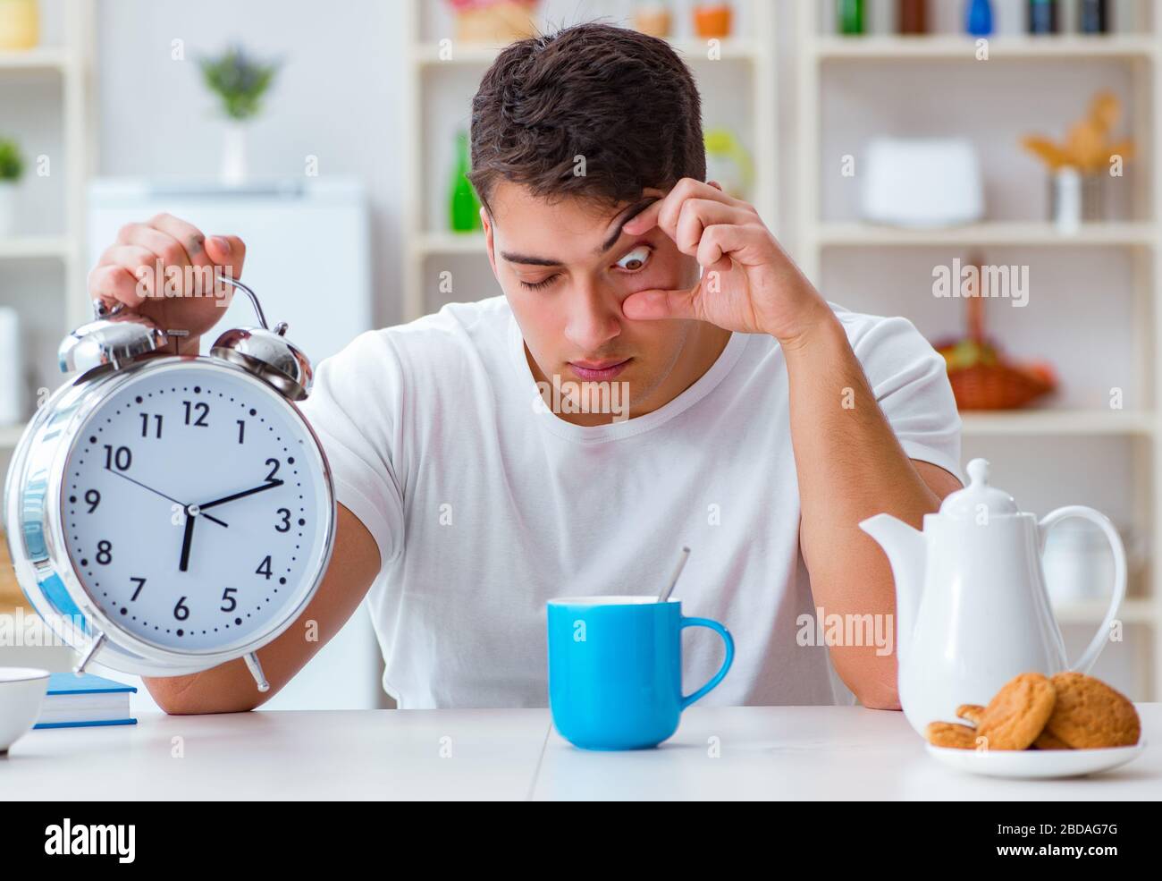 The man with alarm clock falling asleep at breakfast Stock Photo - Alamy