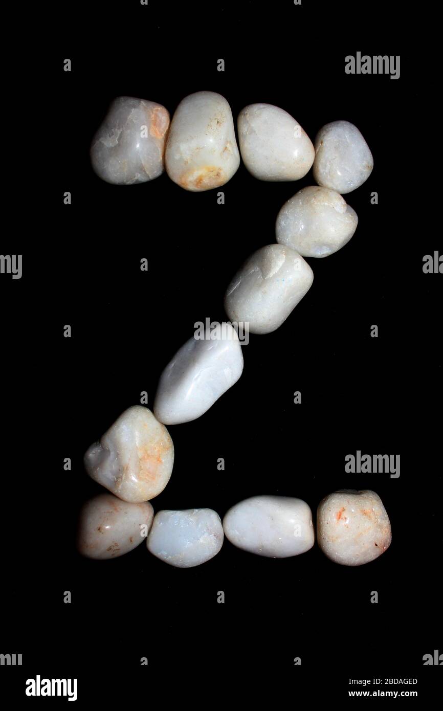 white royal sapphire rock pebbles letter, alphabet photographed against ...