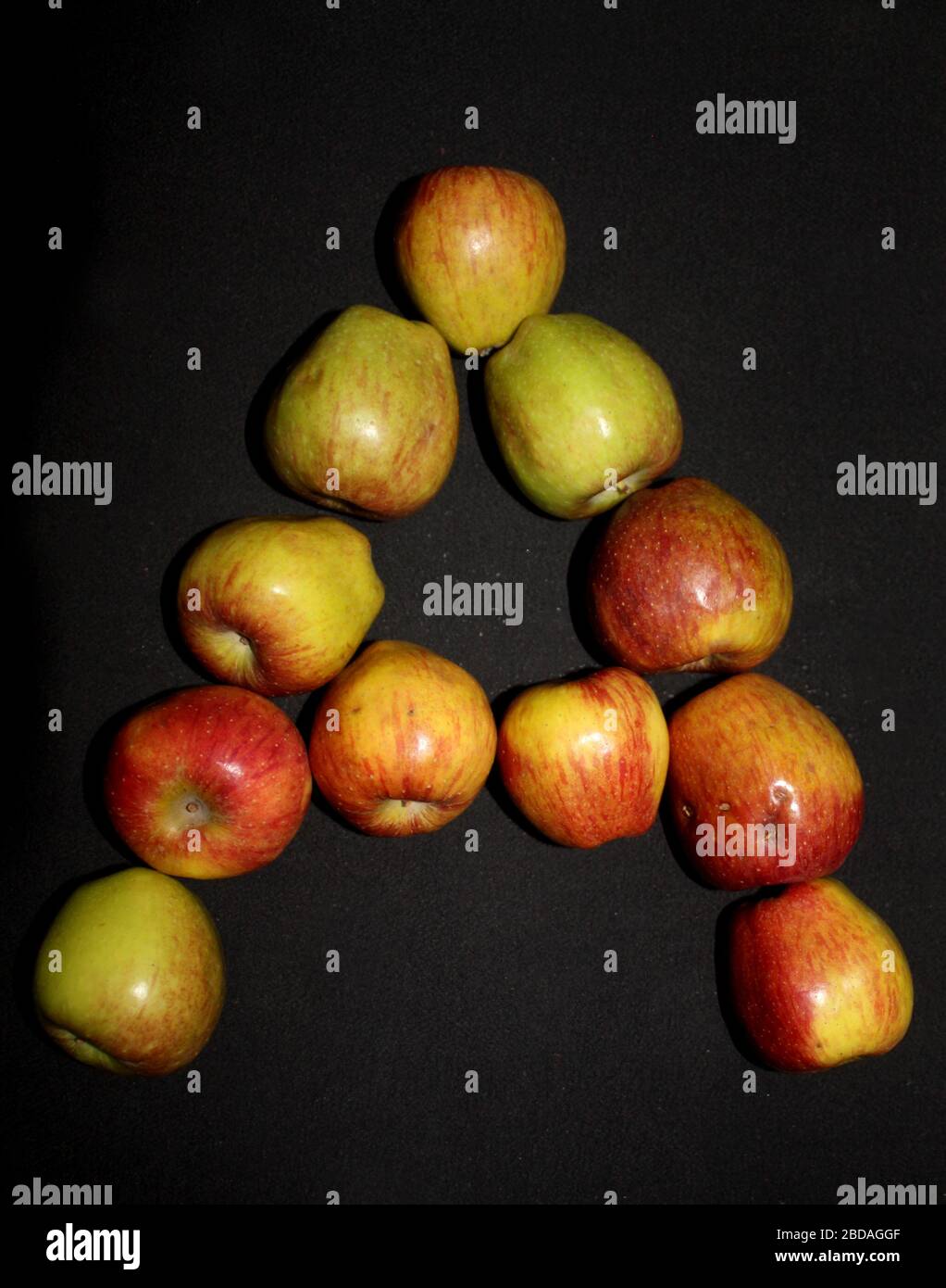 Colorful fresh apples letter alphabet photographed against a black ...