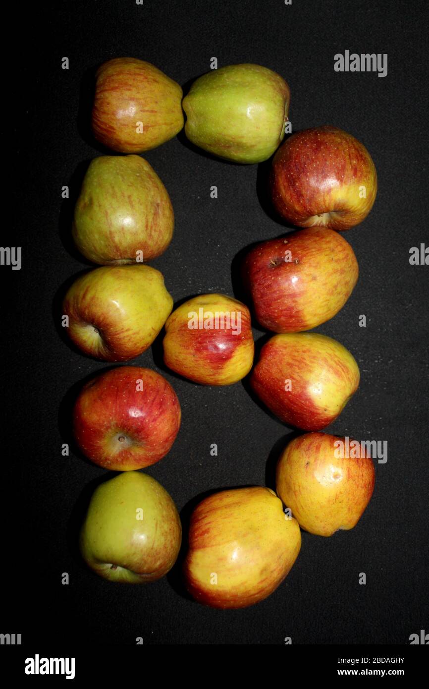 Colorful fresh apples letter alphabet photographed against a black ...
