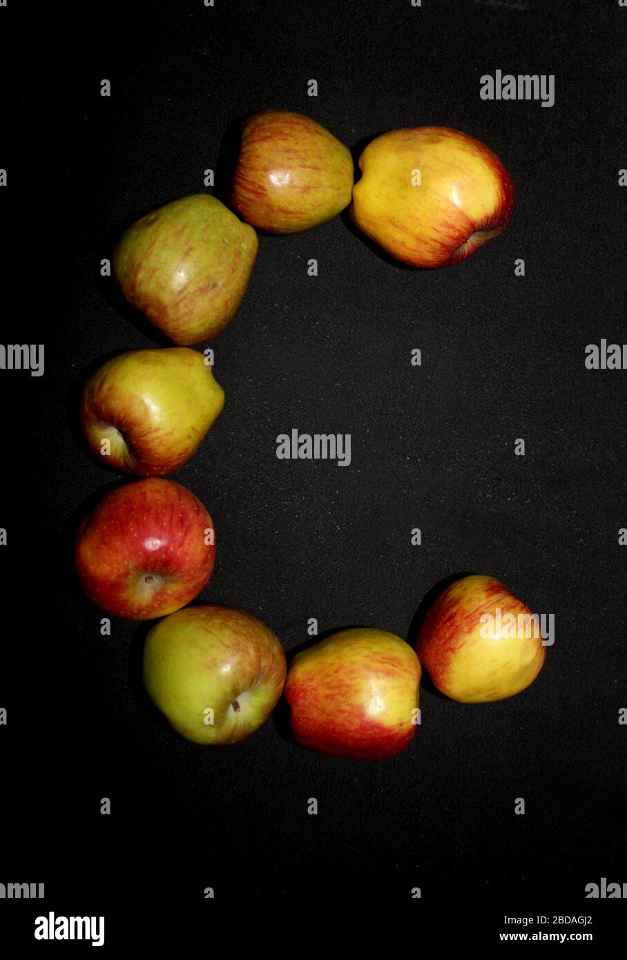 Colorful fresh apples letter alphabet photographed against a black ...