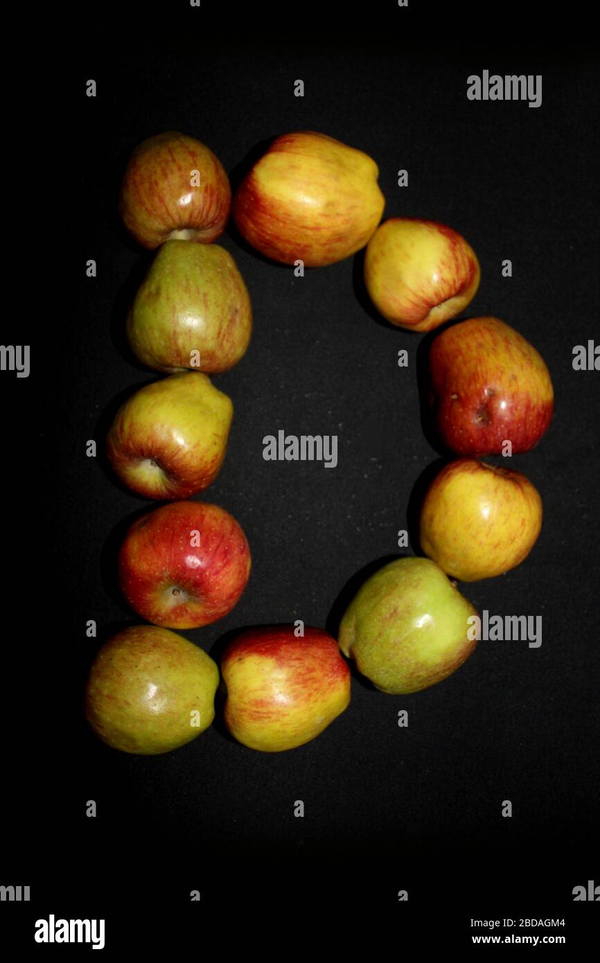 Colorful fresh apples letter alphabet photographed against a black ...