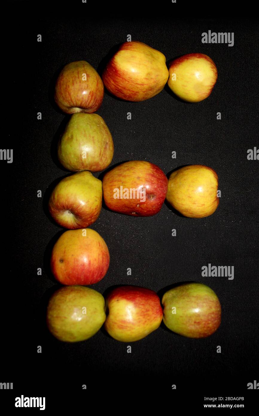 Colorful fresh apples letter alphabet photographed against a black ...