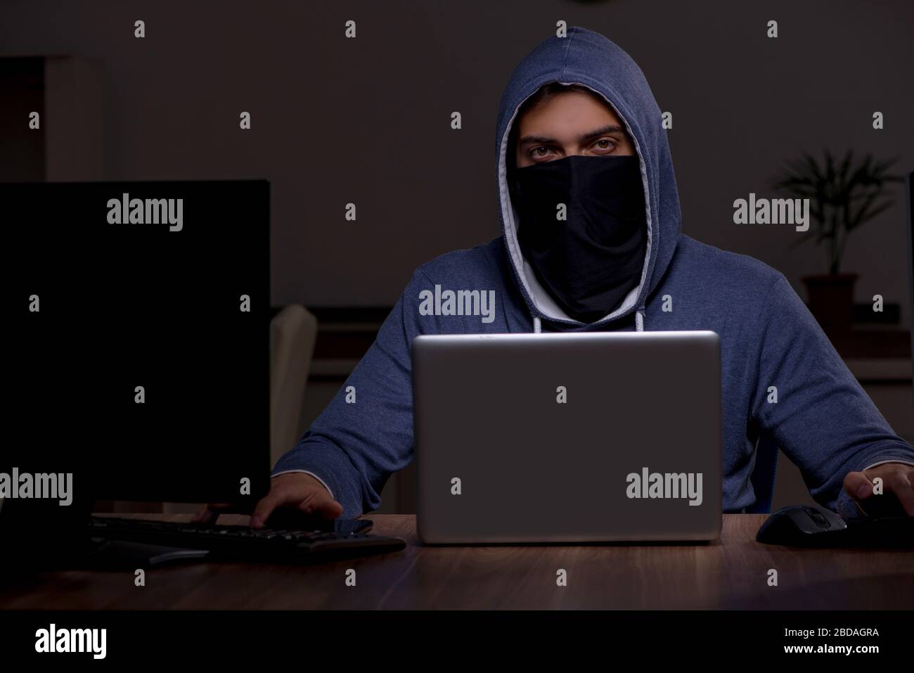 Male hacker hacking security firewall late in the office Stock Photo ...