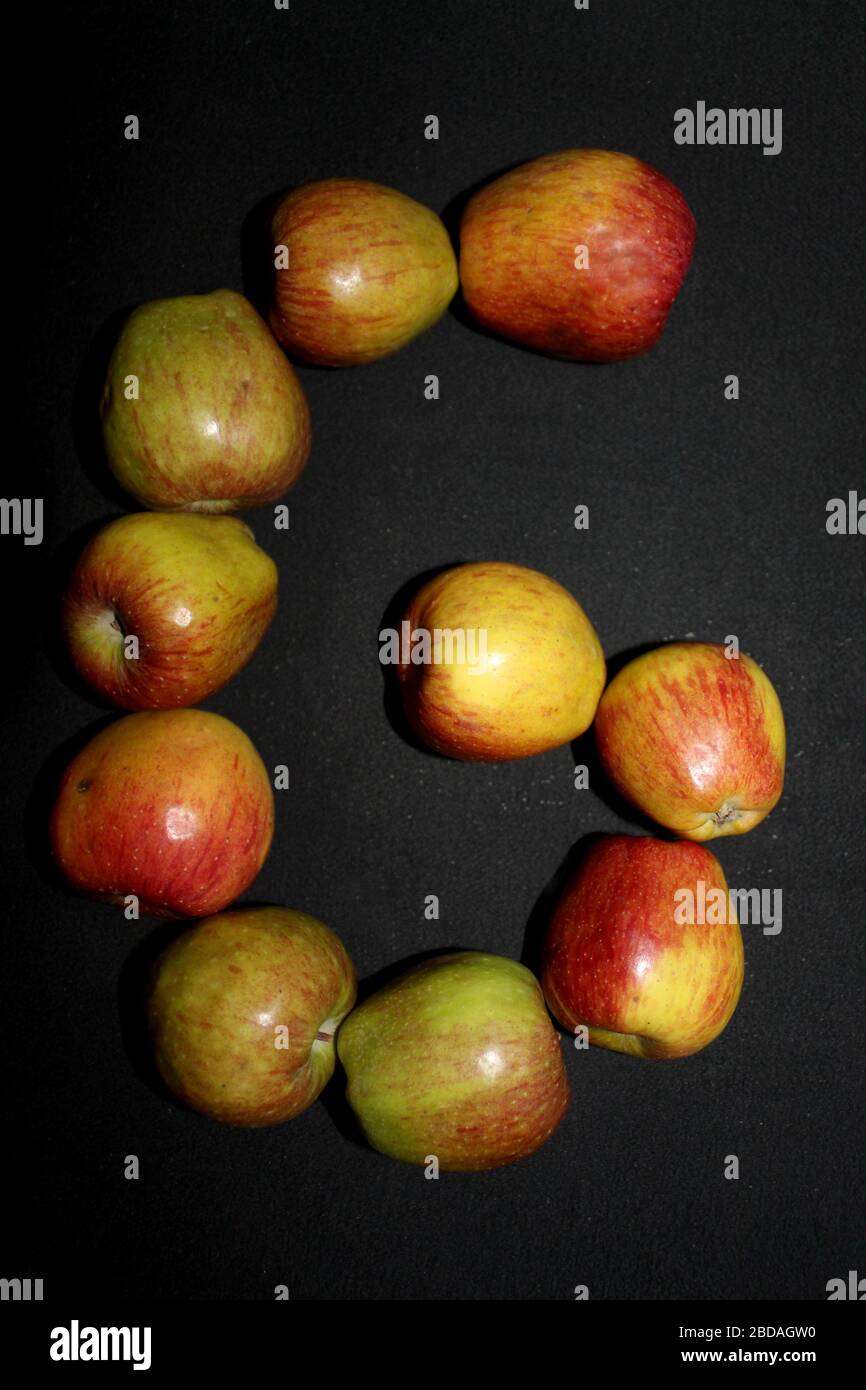 Colorful fresh apples letter alphabet photographed against a black ...