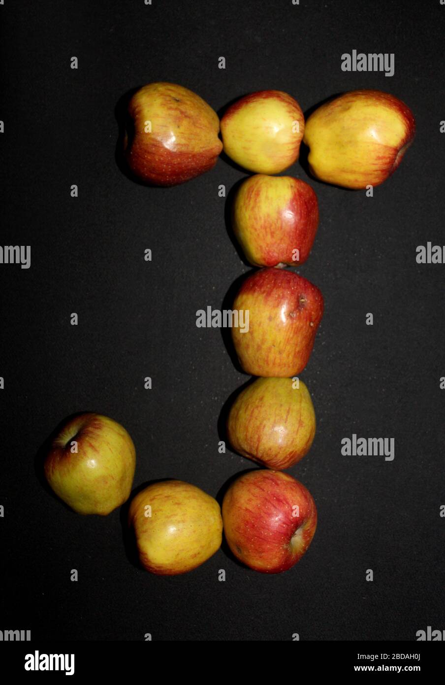 Colorful fresh apples letter alphabet photographed against a black ...