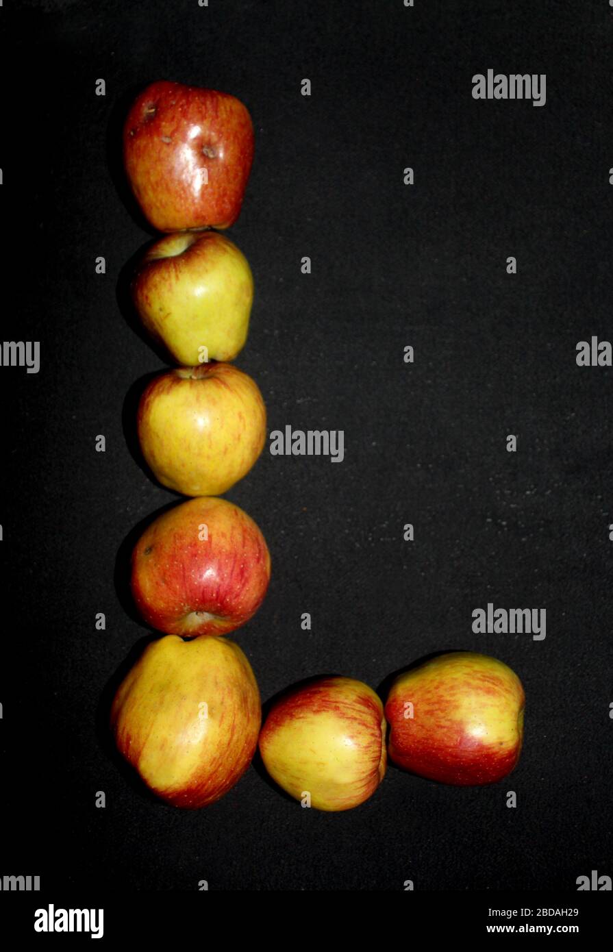 Colorful fresh apples letter alphabet photographed against a black ...