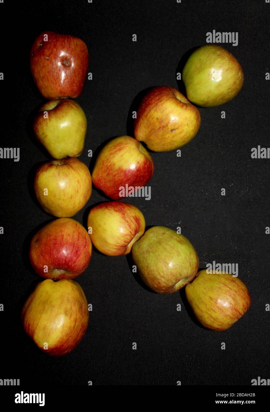 Colorful fresh apples letter alphabet photographed against a black ...