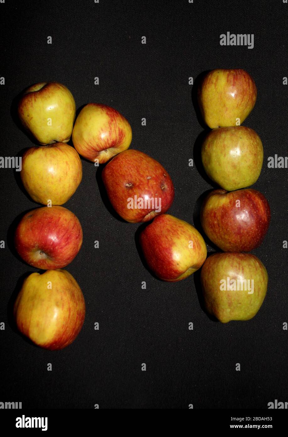 Colorful fresh apples letter alphabet photographed against a black ...