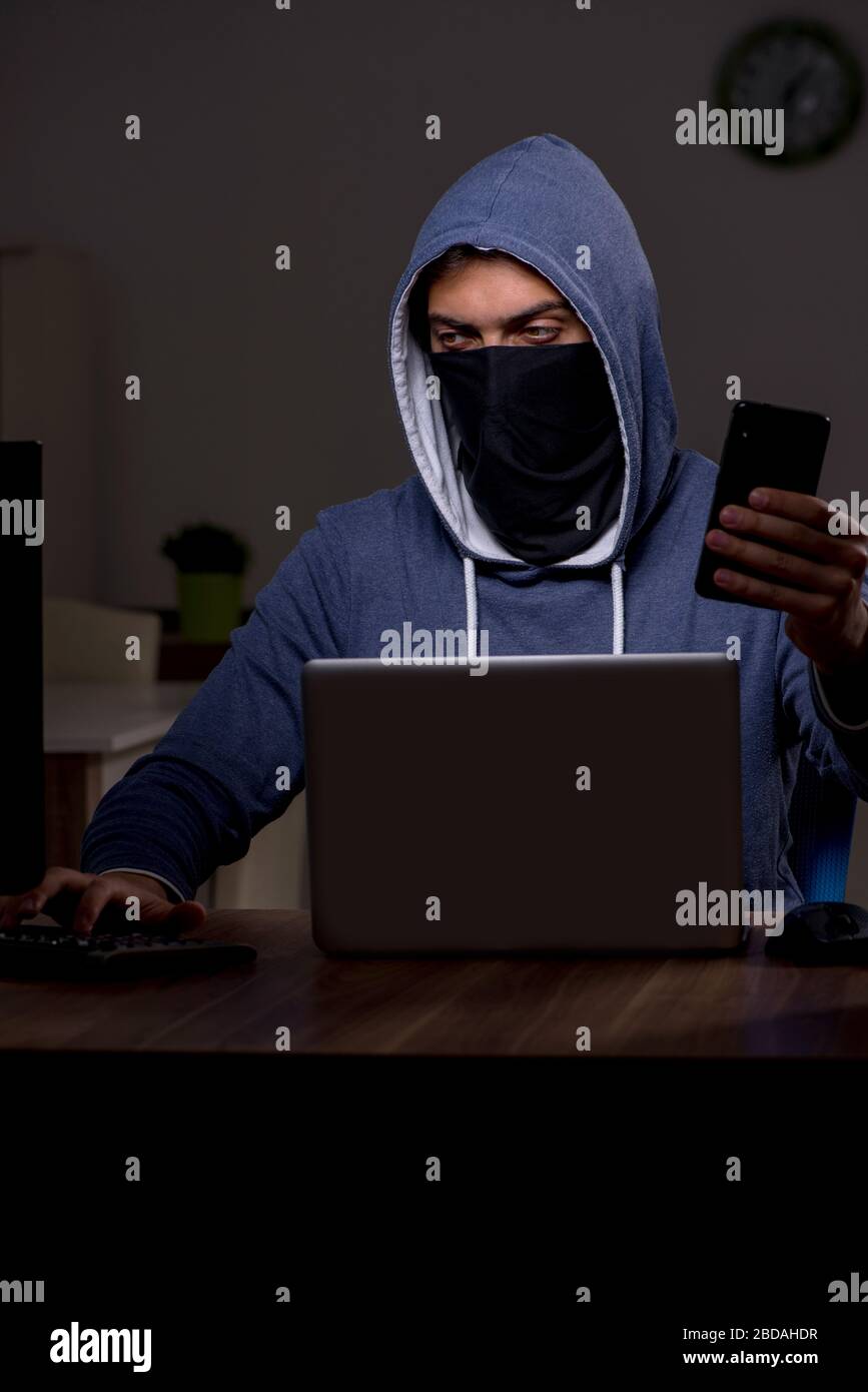 Male hacker hacking security firewall late in the office Stock Photo ...