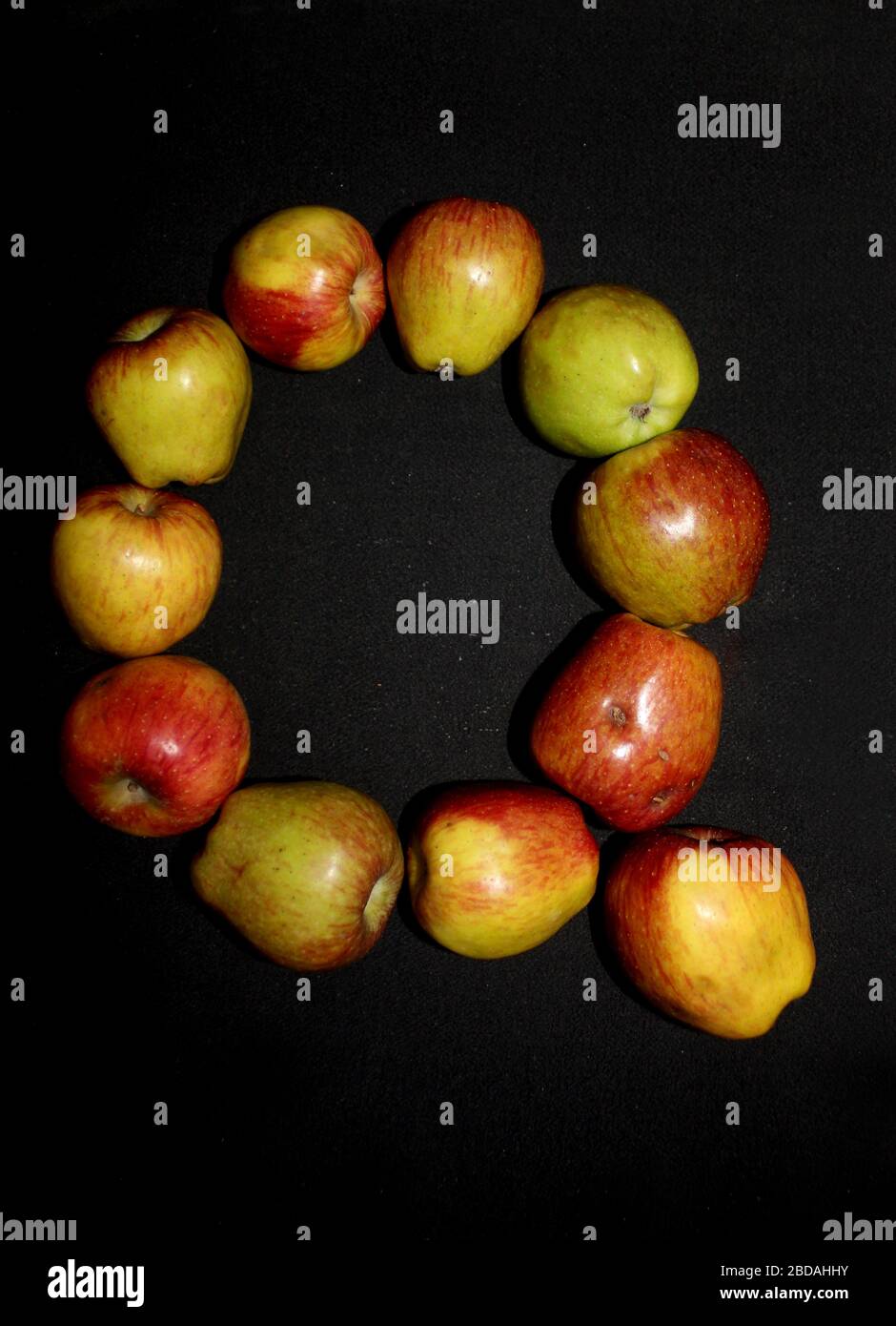 Colorful fresh apples letter alphabet photographed against a black ...