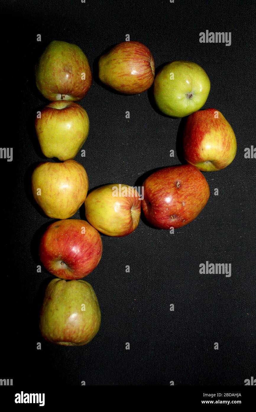 Colorful fresh apples letter alphabet photographed against a black ...