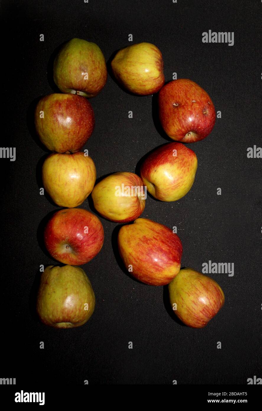 Colorful fresh apples letter alphabet photographed against a black ...