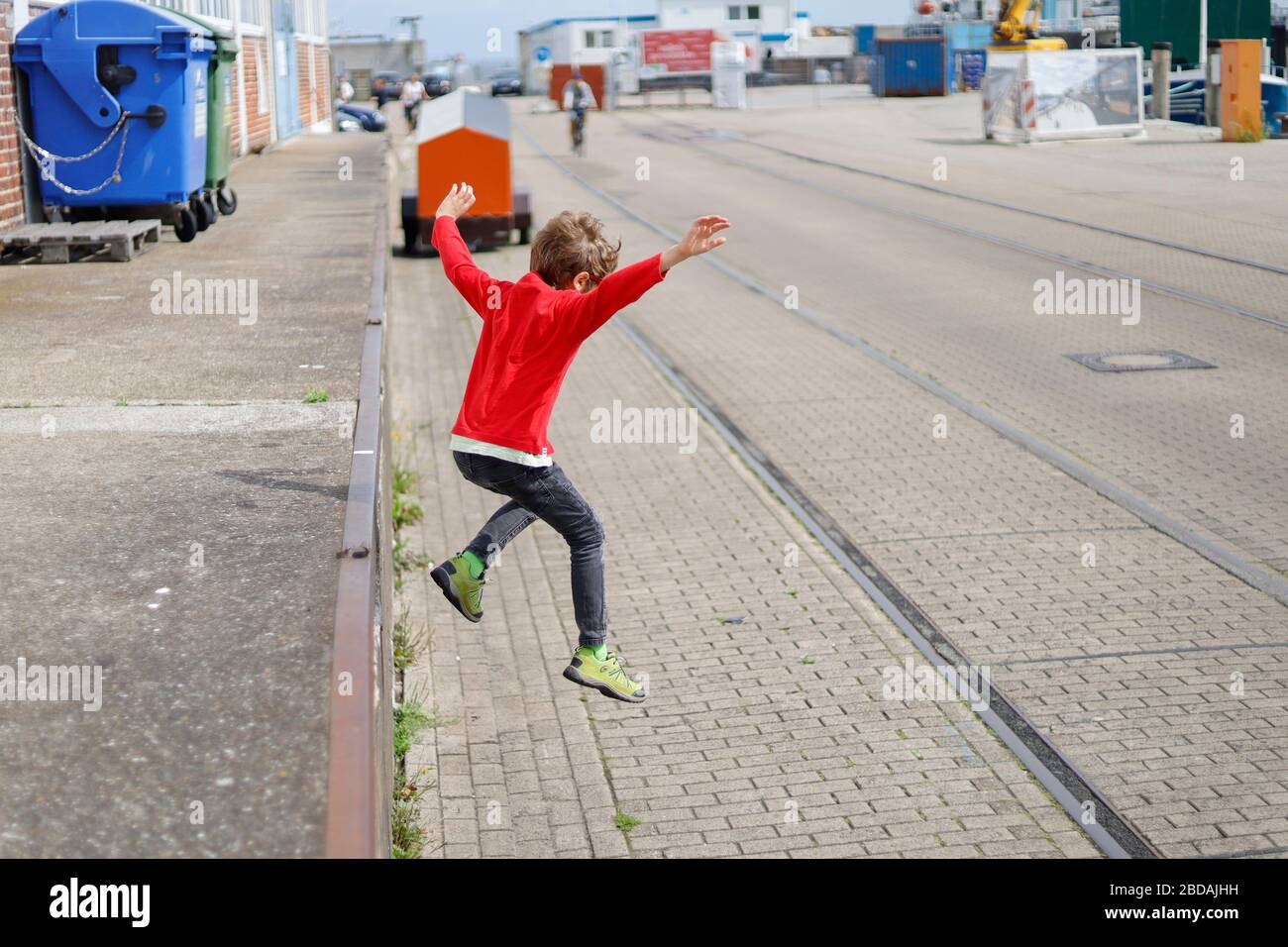 Cuxhaven, 08.08.19: a young boy jumps from a wall Stock Photo - Alamy