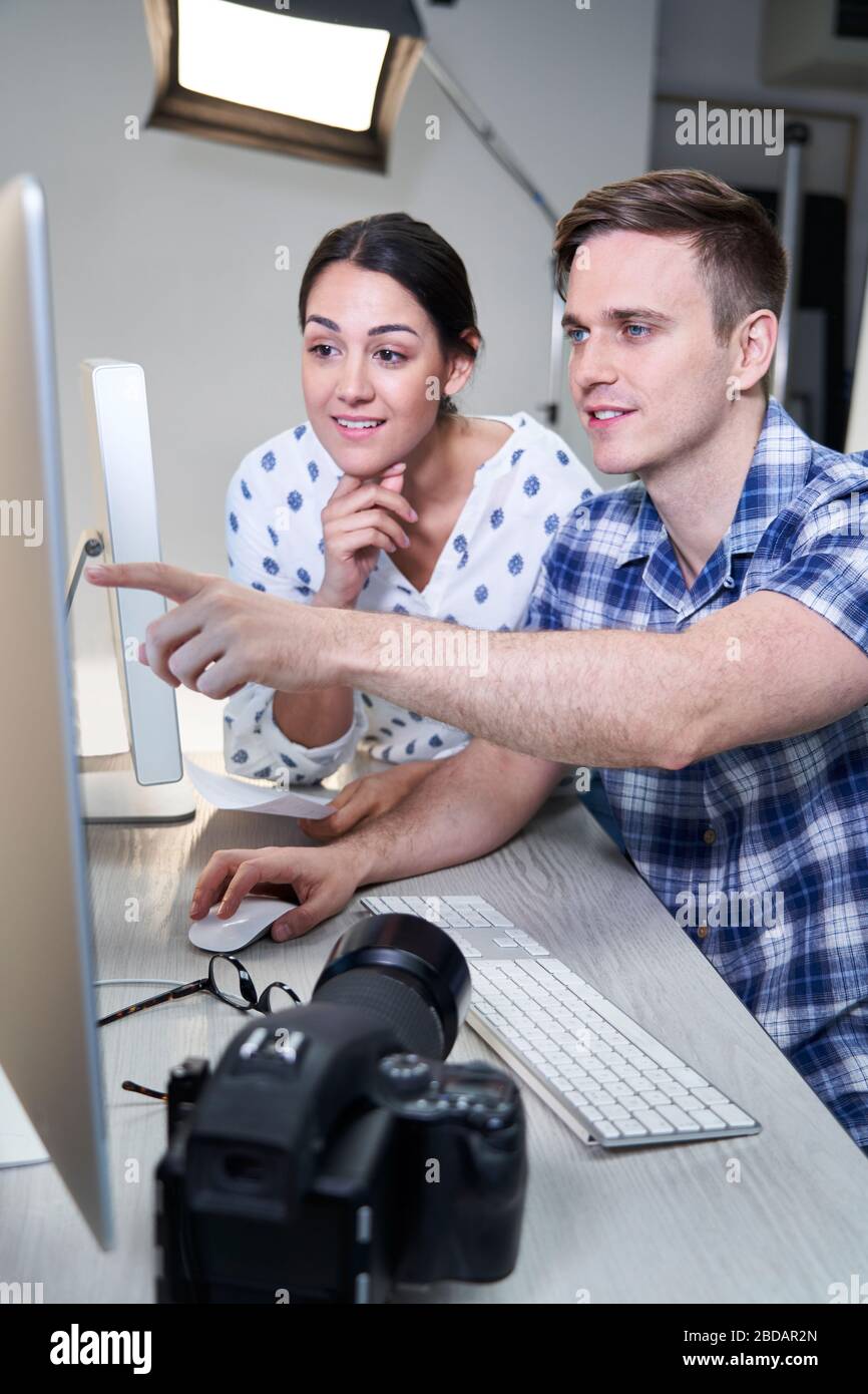 Photographer In Studio Reviewing Images From Photo Shoot On Computer ...