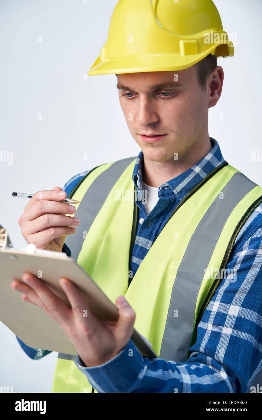 Builder Architect Making Notes On Clipboard Against White Background ...
