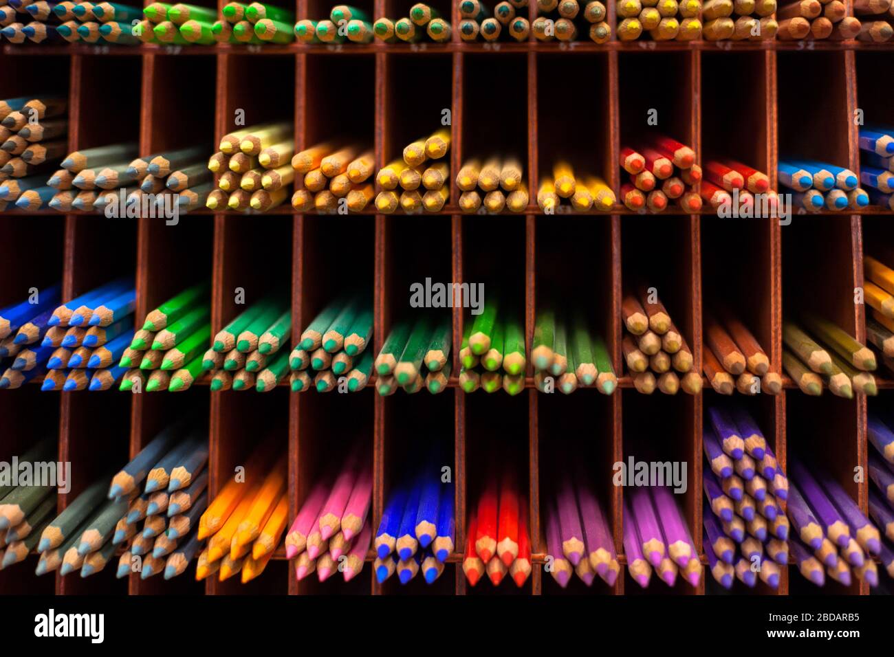 Colored pencils lie on the shelves in the store. Small depth of field ...