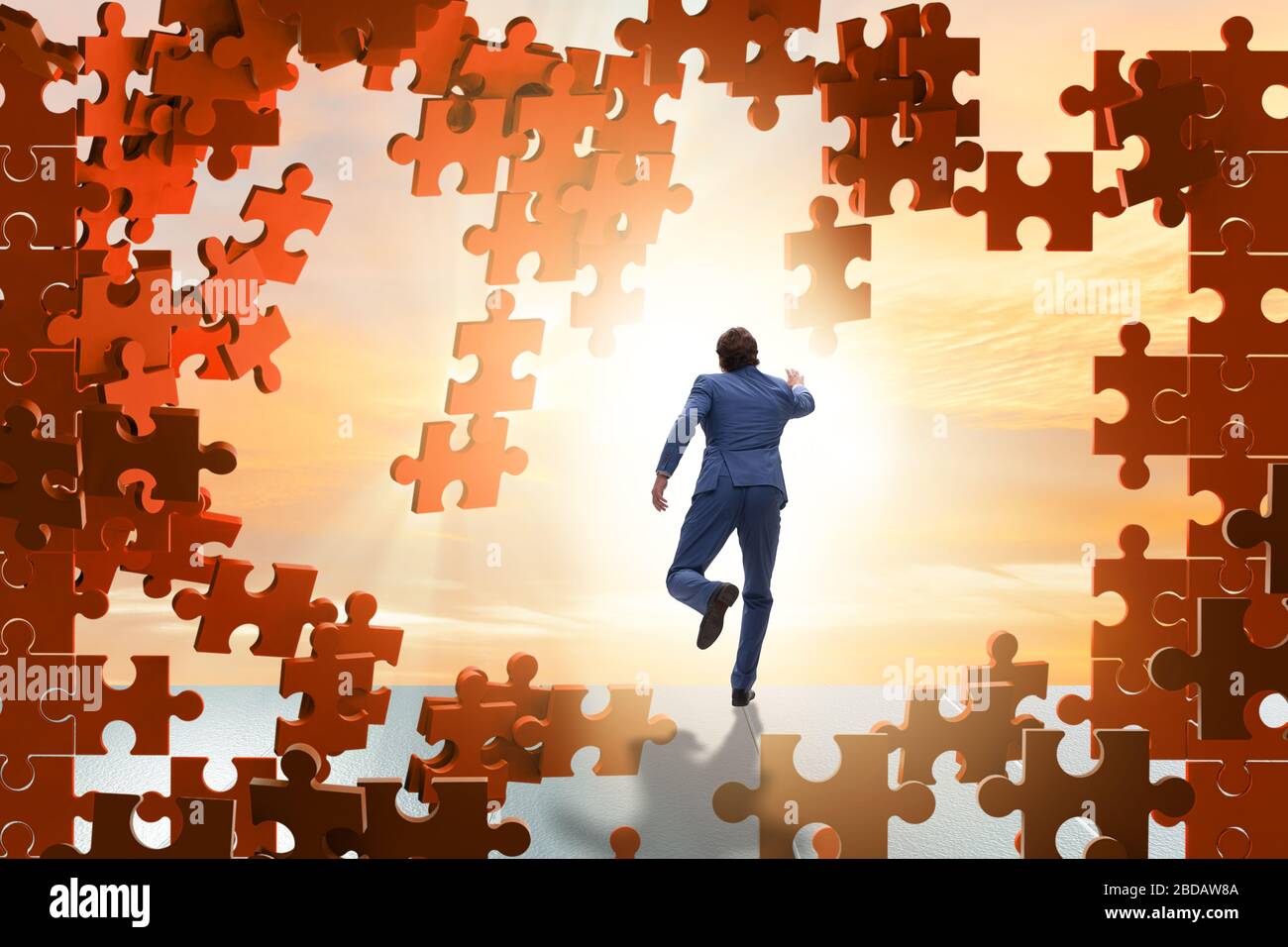The businessman breaking the wall of jigsaw puzzle Stock Photo - Alamy