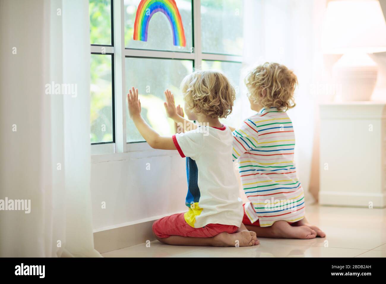 Coronavirus quarantine. Stay home. Kids sitting at window. Children ...