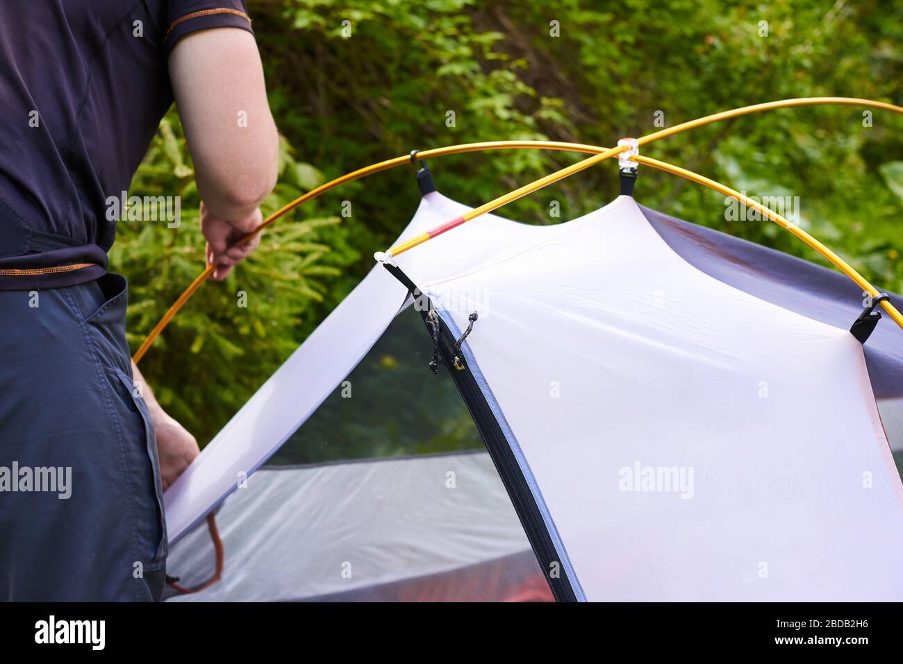 Step by step guide on how to set up a tent. tourists put up a tent in a ...