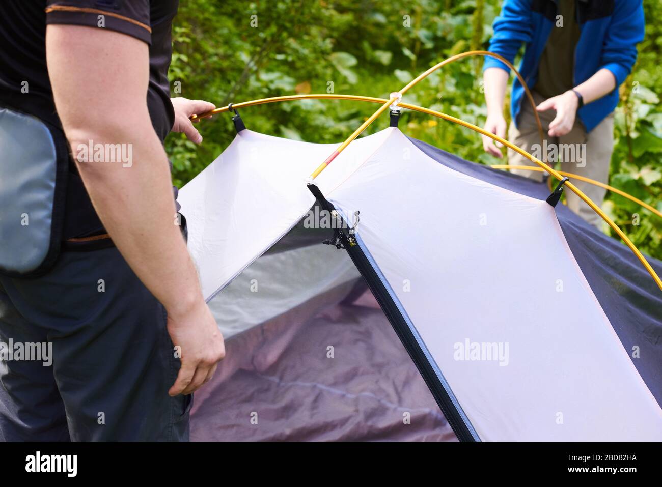 Step by step guide on how to set up a tent. tourists put up a tent in a ...