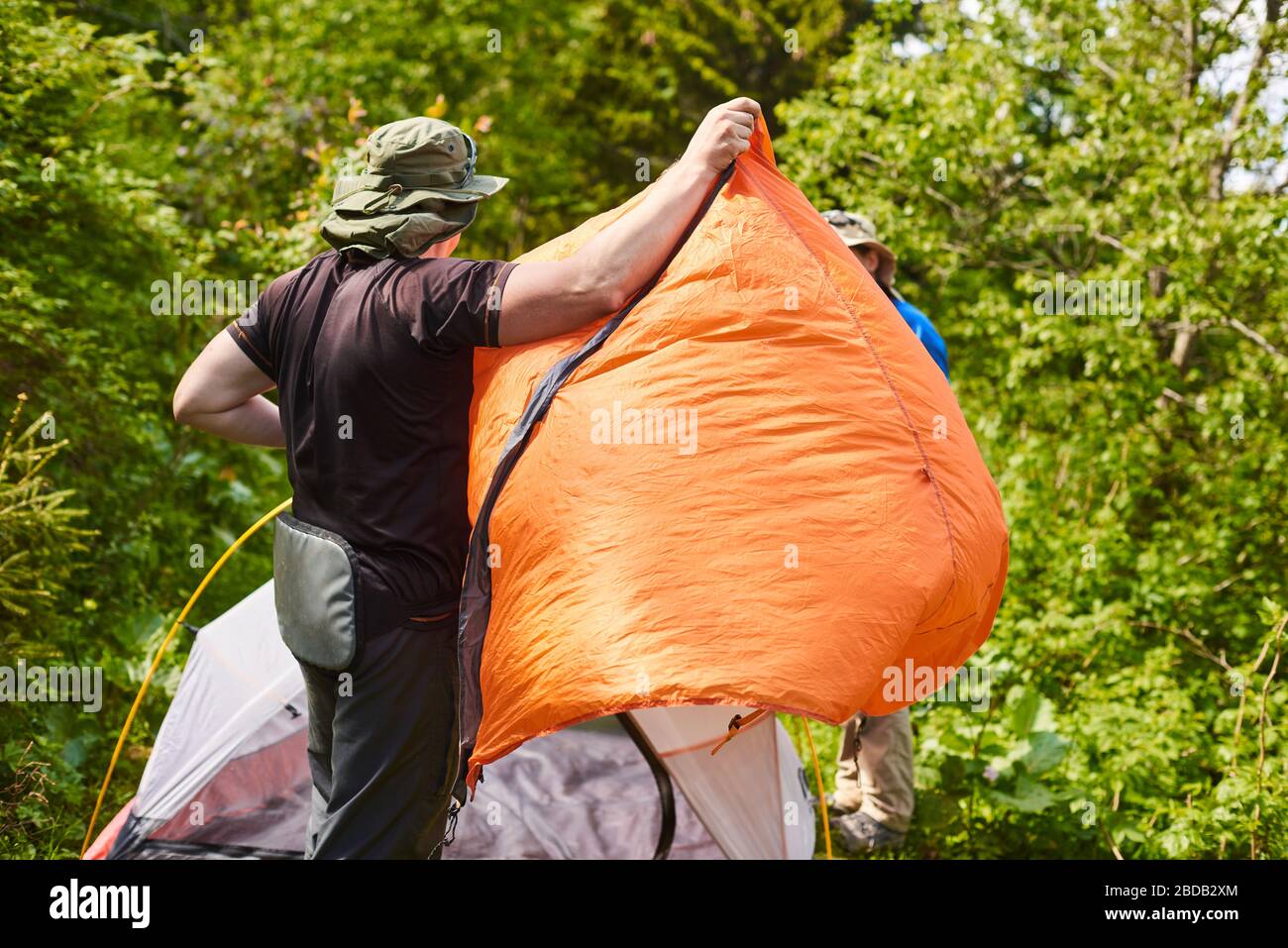 Step by step guide on how to set up a tent. tourists put up a tent in a ...