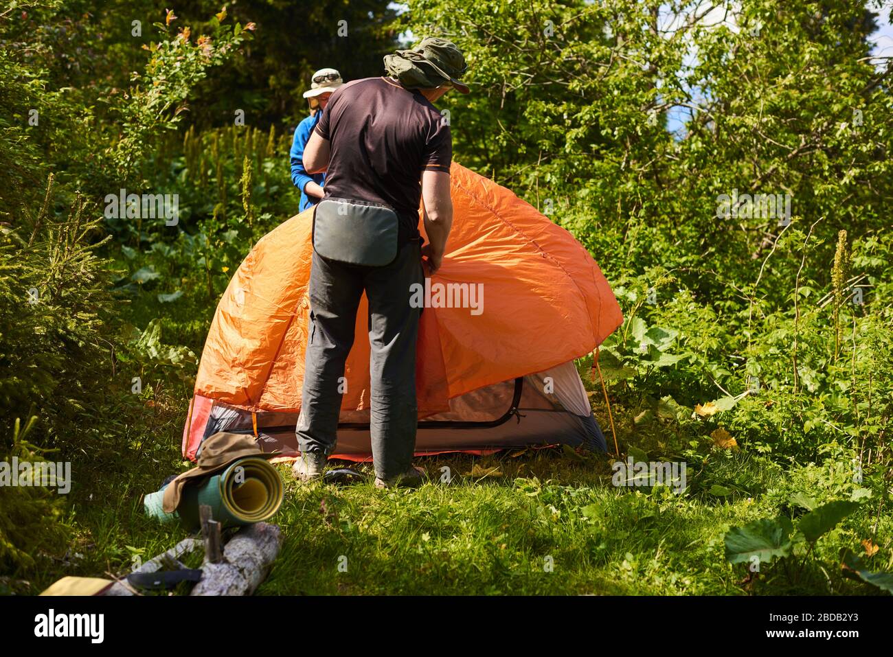 Step by step guide on how to set up a tent. tourists put up a tent in a ...
