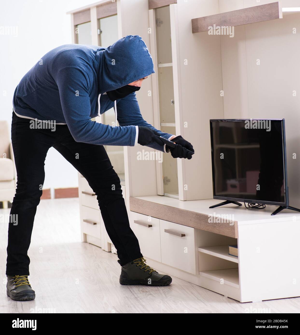 The man burglar stealing tv set from house Stock Photo - Alamy