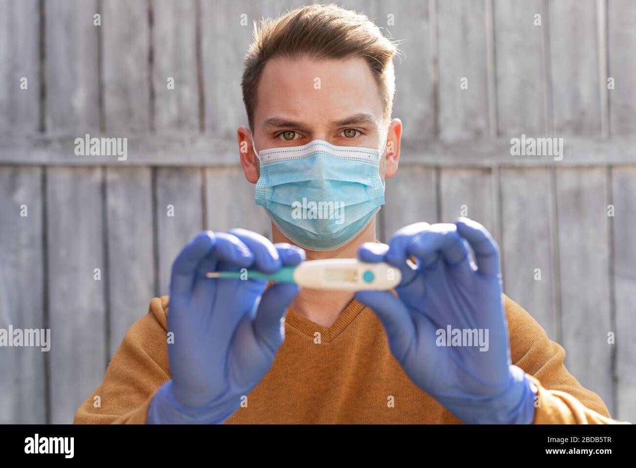 Portrait of a young man contaminated with covid-19 is wearing mask and ...