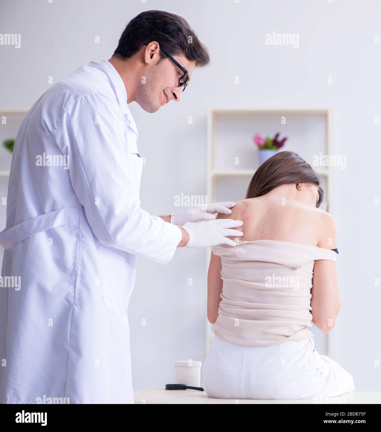The doctor examining the skin of female patient Stock Photo - Alamy