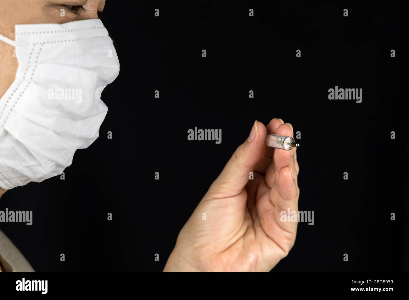 Female ware surgical mask and looking at thermometer check their body ...
