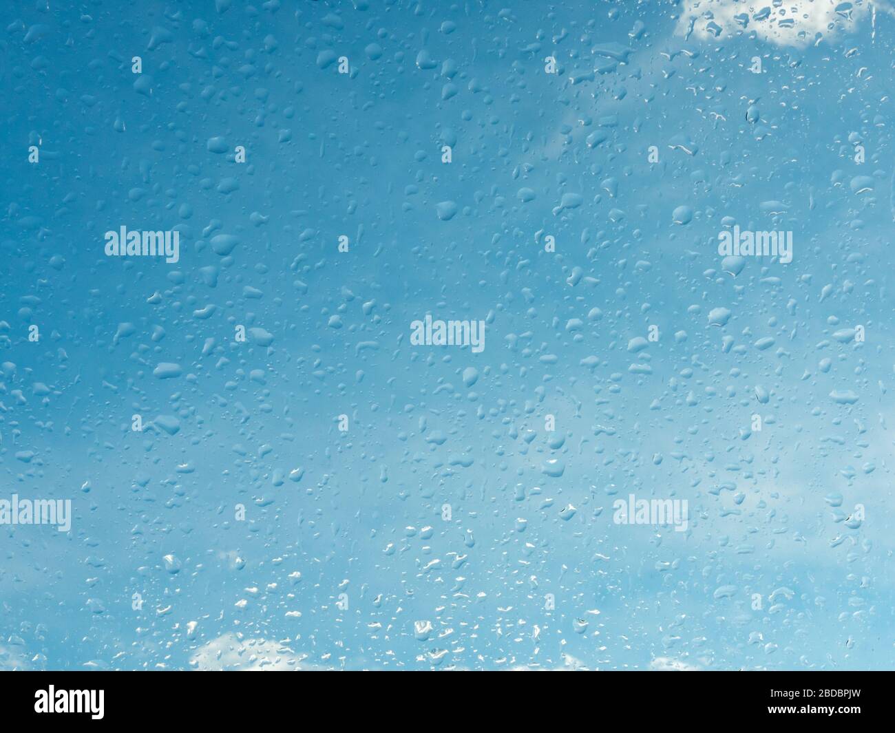 Wet window with rain drops and a cloudy sky outside background Stock ...