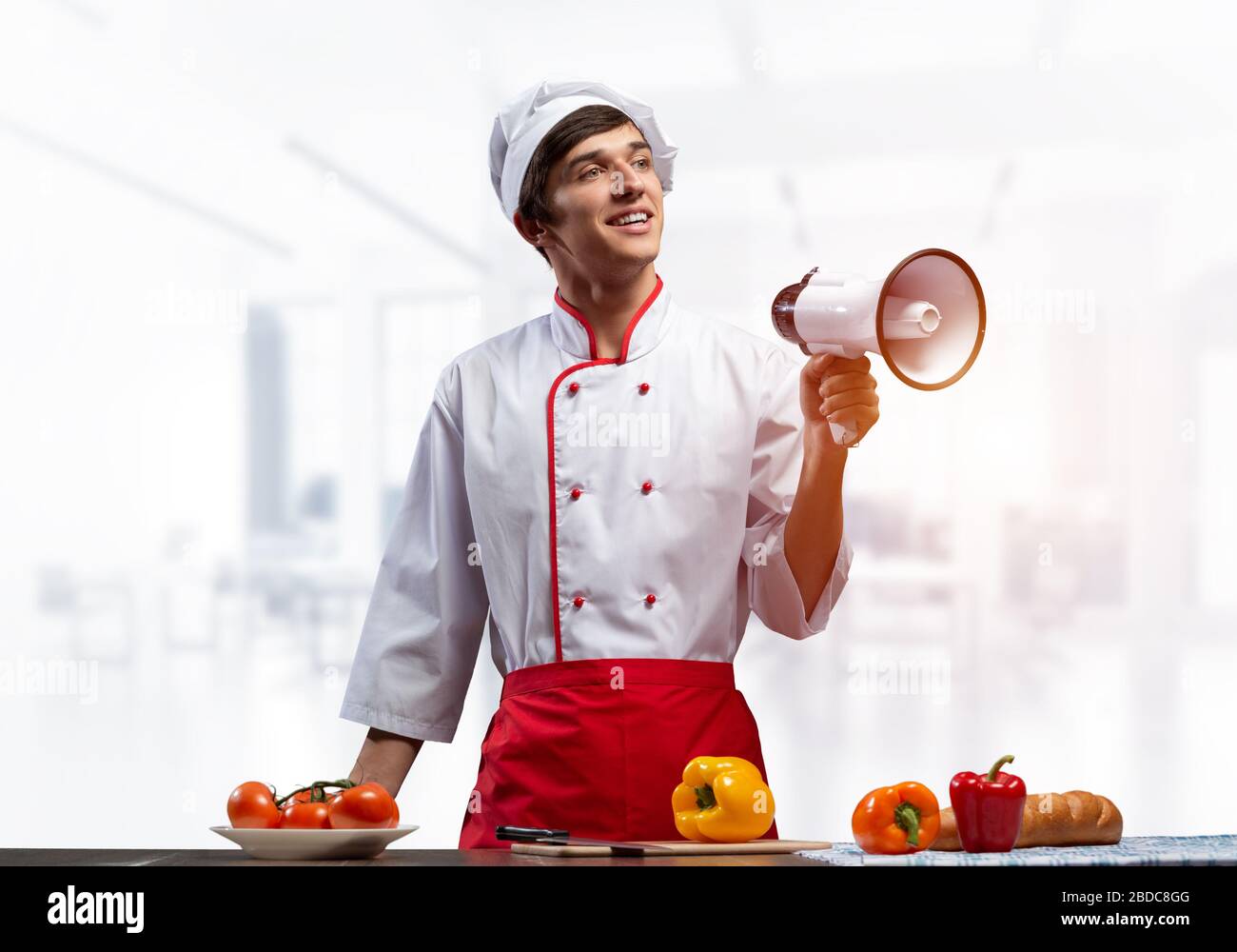 Young chef standing with megaphone in hand Stock Photo - Alamy