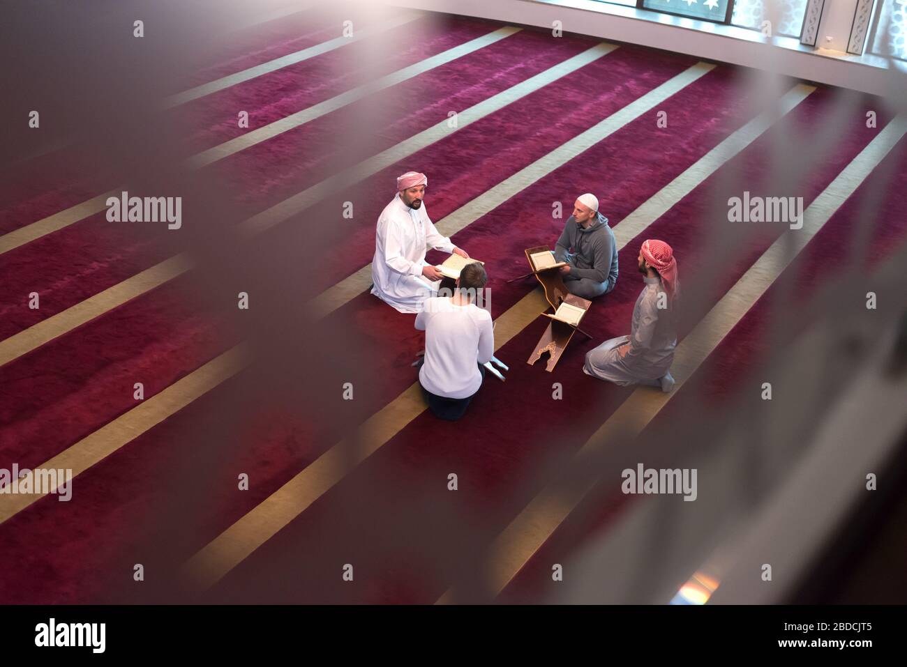 Group of muliethnic religious muslim young people praying and reading ...