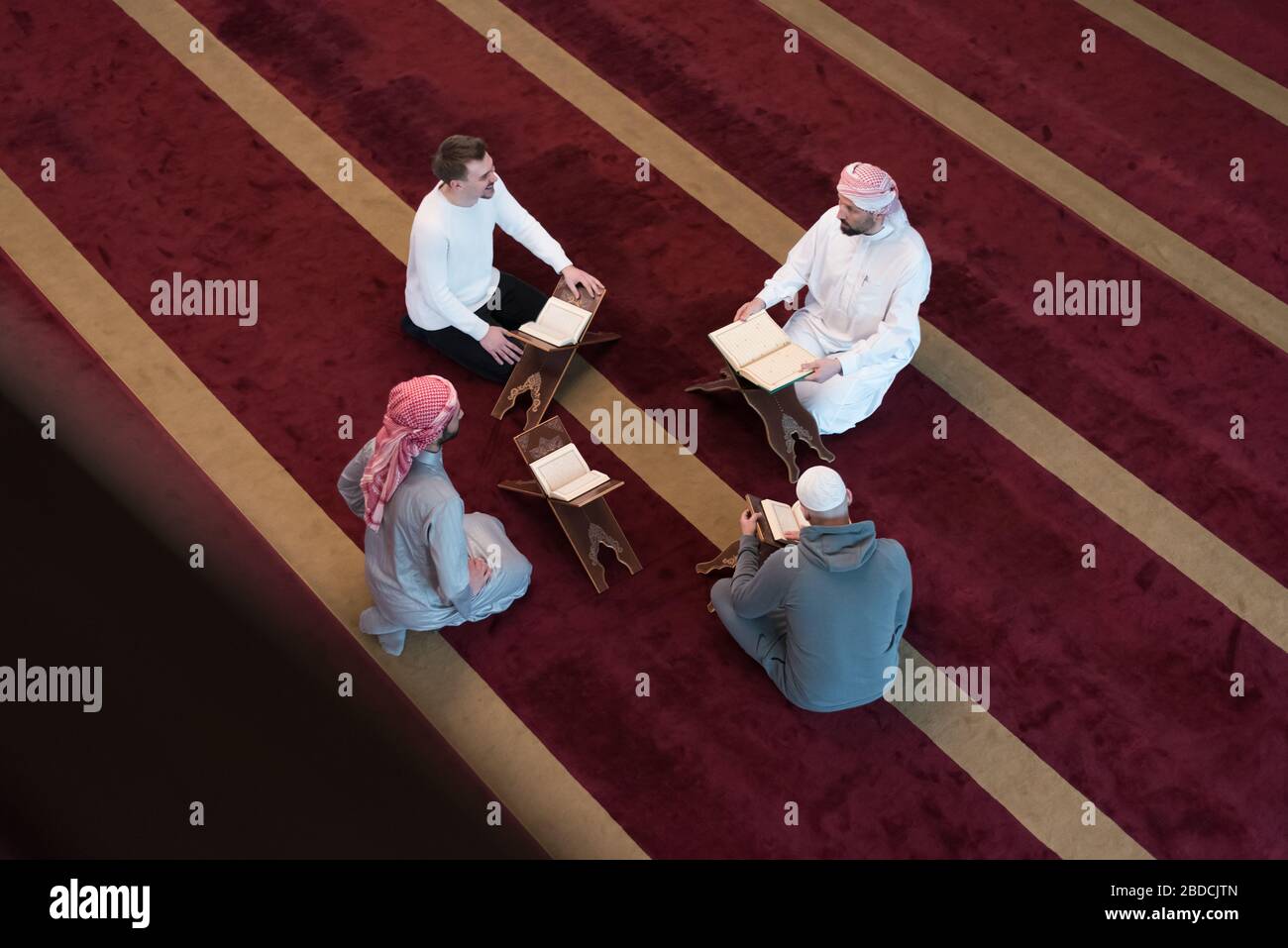 Group of muliethnic religious muslim young people praying and reading ...