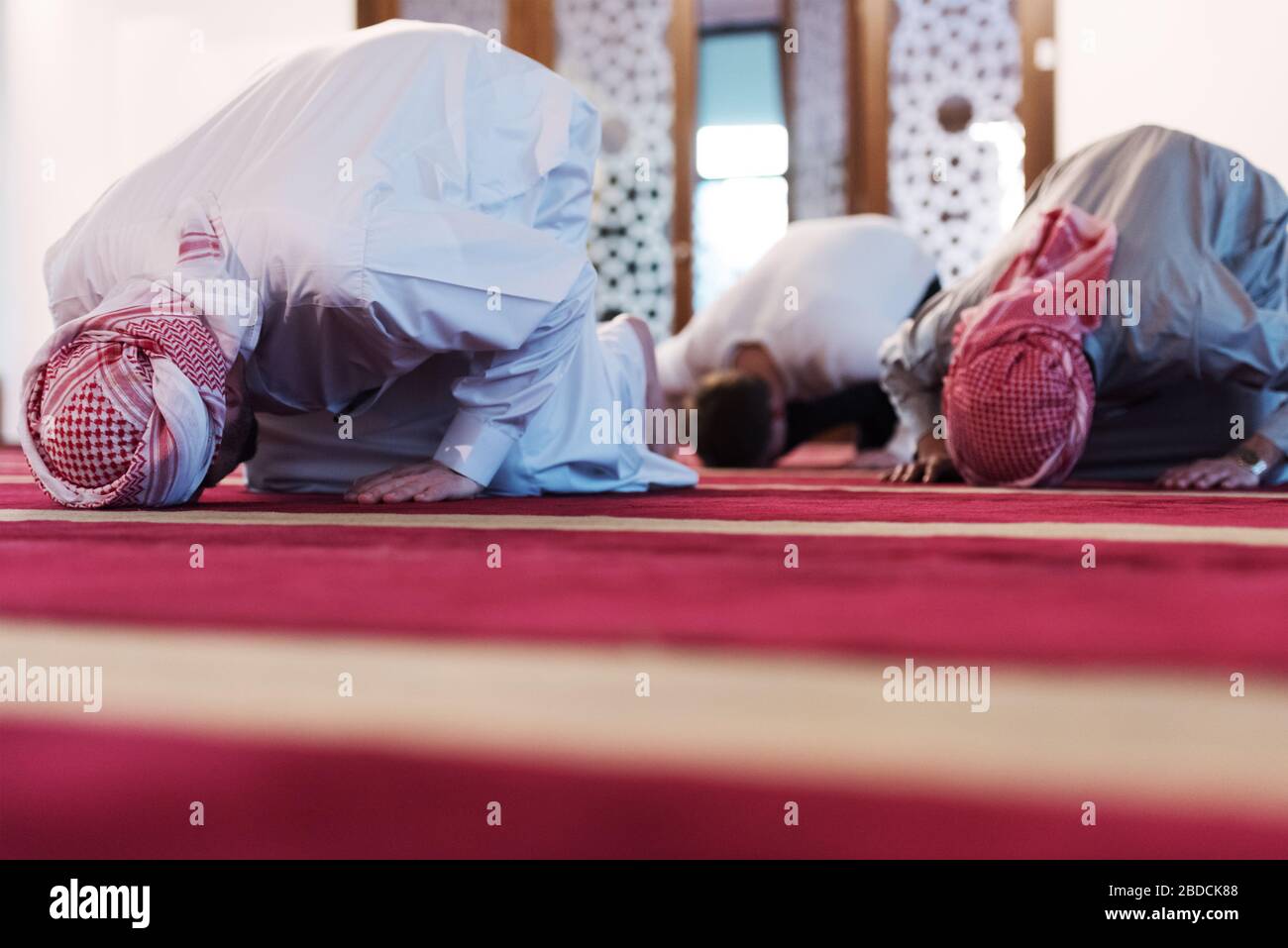 Group of muliethnic religious muslim young people praying and reading ...
