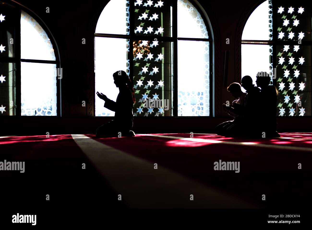 Group of muliethnic religious muslim young people praying and reading ...