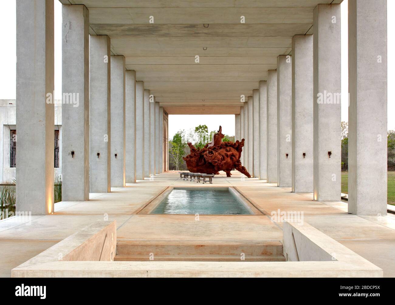 Colonnade with open air pool hall and large sculpture beyond. Plantel ...