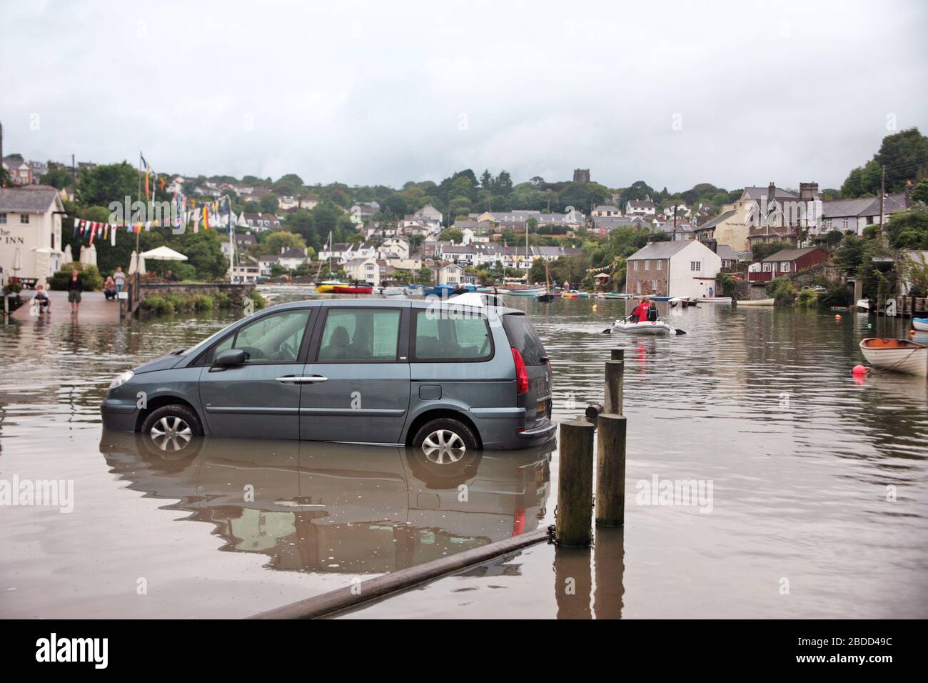 Car marooned by the rising spring tide in Mayo Creek, Noss Mayo, Devon ...
