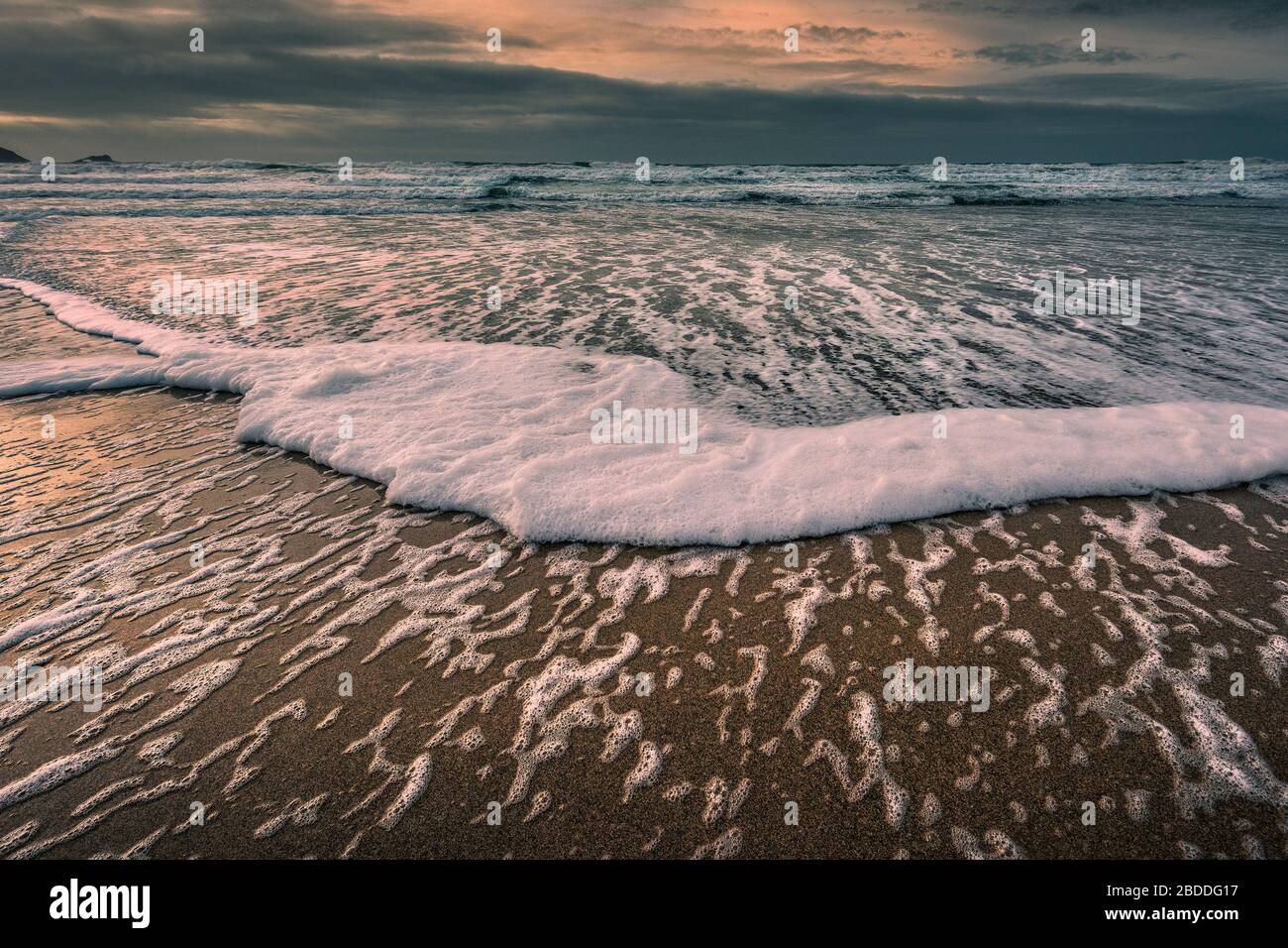 Evening light over an incoming tide at Fistral Beach in Newquay in ...