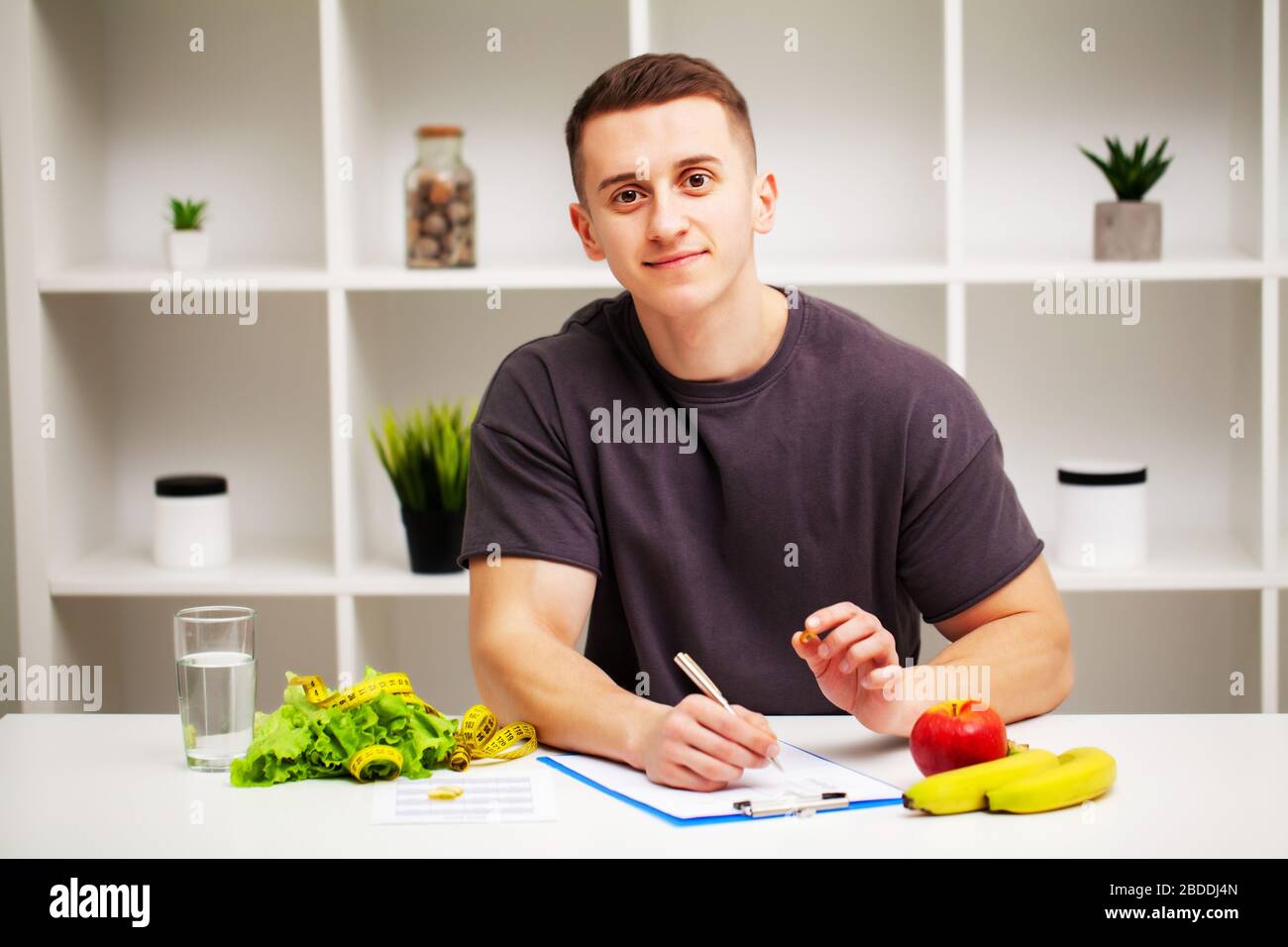 Trainer draws up a training program and a healthy diet plan Stock Photo ...