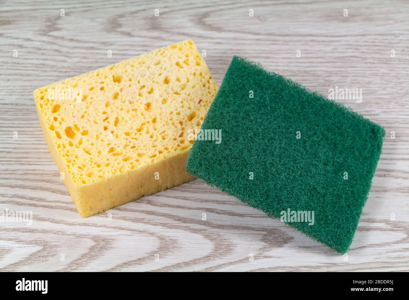 Yellow synthetic sponge and green scrub pad Stock Photo - Alamy