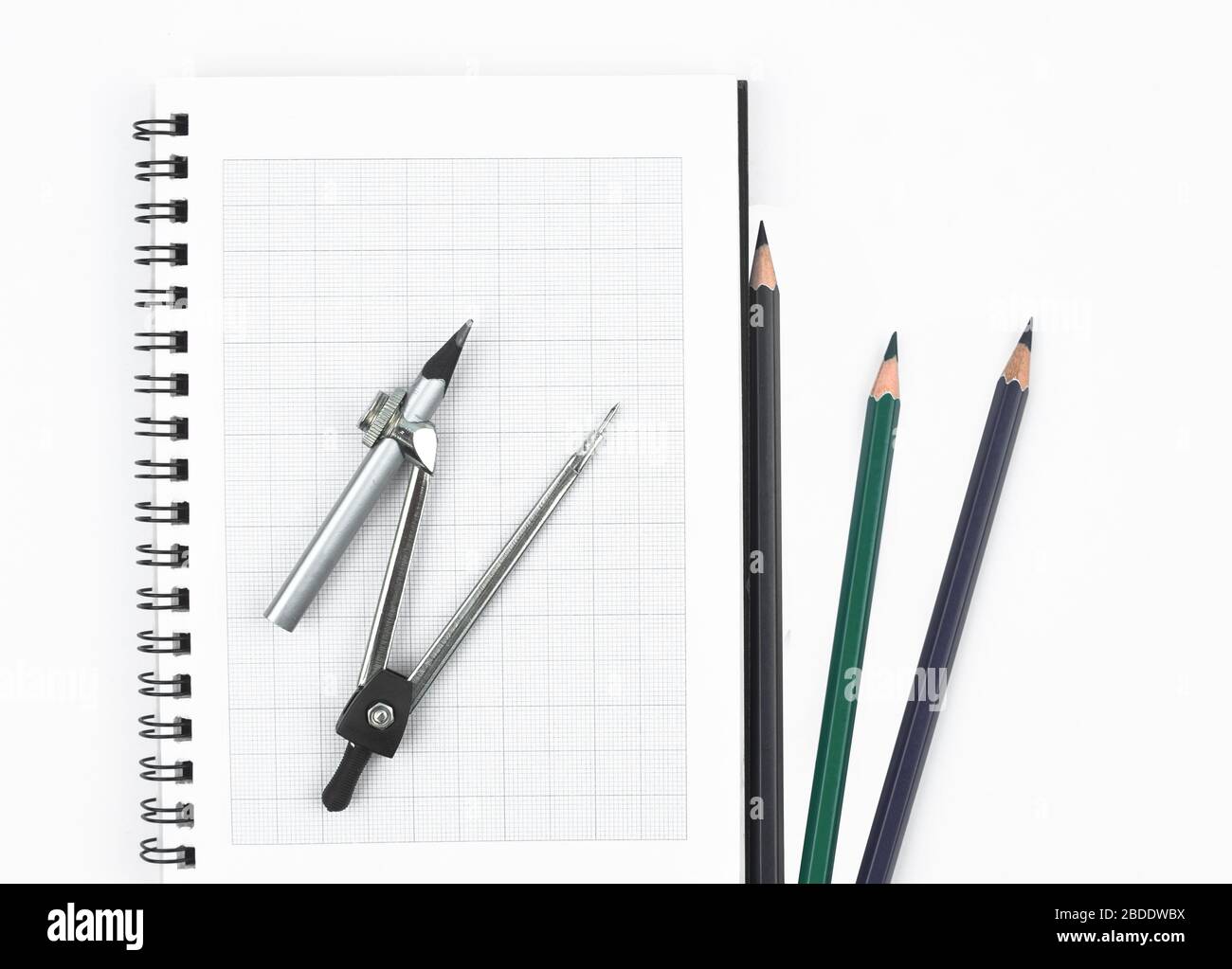 A pencil compass attached to a silver pencil placed on top of a white ...