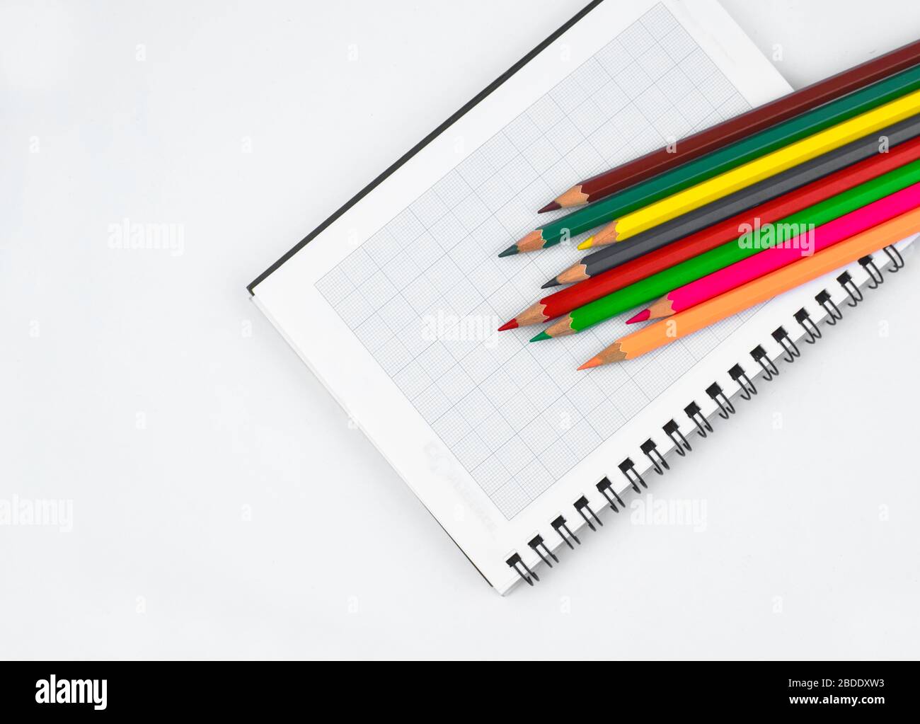 Some different colored pencil crayons scattered on top of an open ...