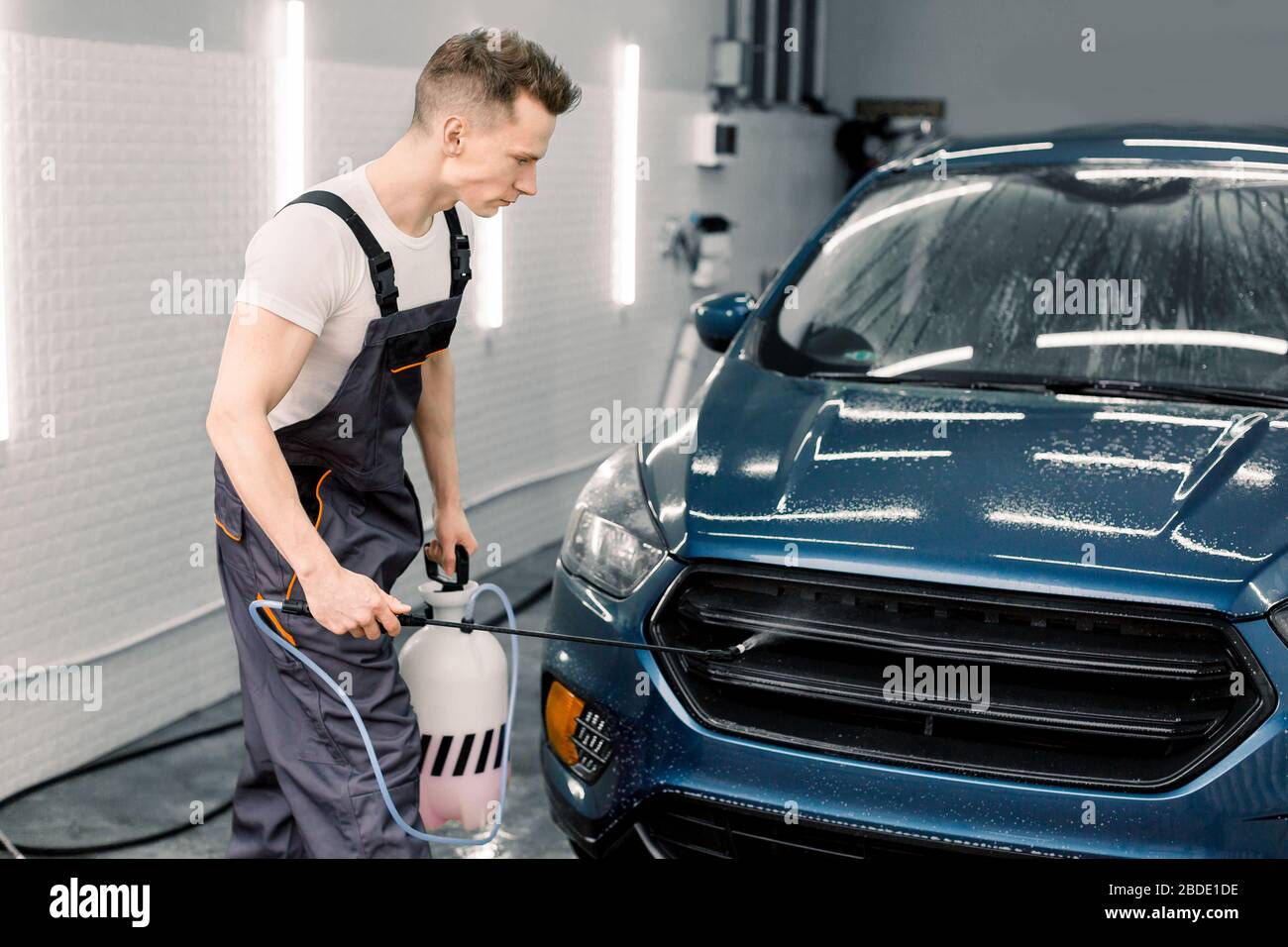 Auto service, car washing and cleaning concept. Handsome young Caucasian male worker in t-shirt ...