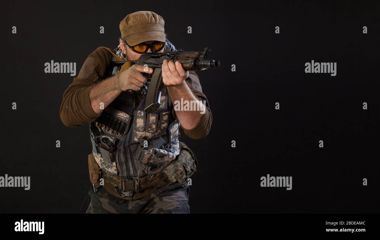 Soldier mercenary with a gun aiming at the enemy. Close up photo on a ...