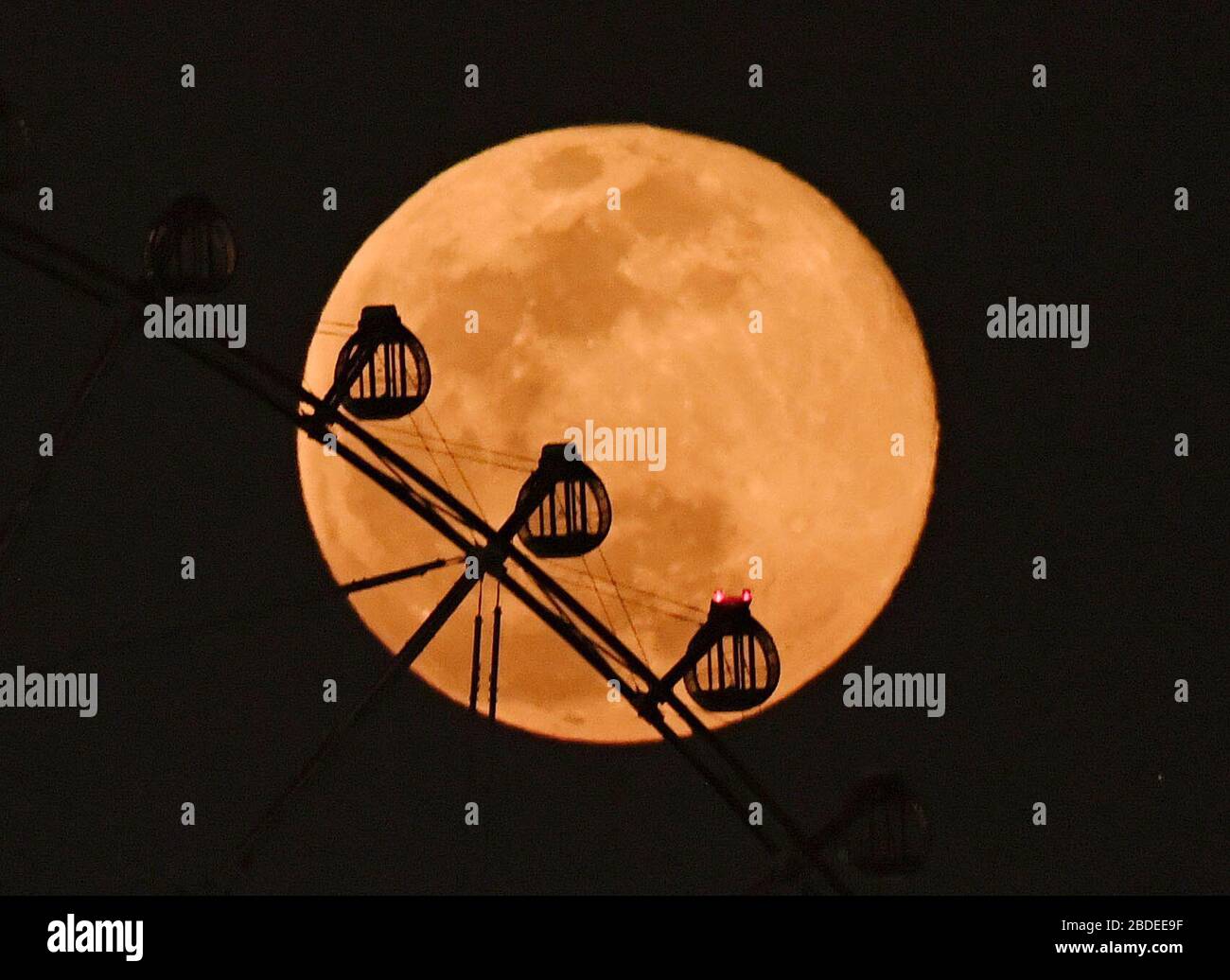 Tokyo, Japan. 08th Apr, 2020. A supermoon is seen behind a Ferris wheel ...
