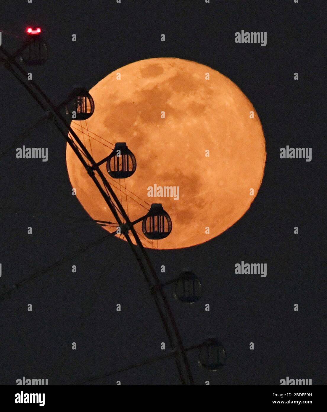 Tokyo, Japan. 08th Apr, 2020. A supermoon is seen behind a Ferris wheel ...