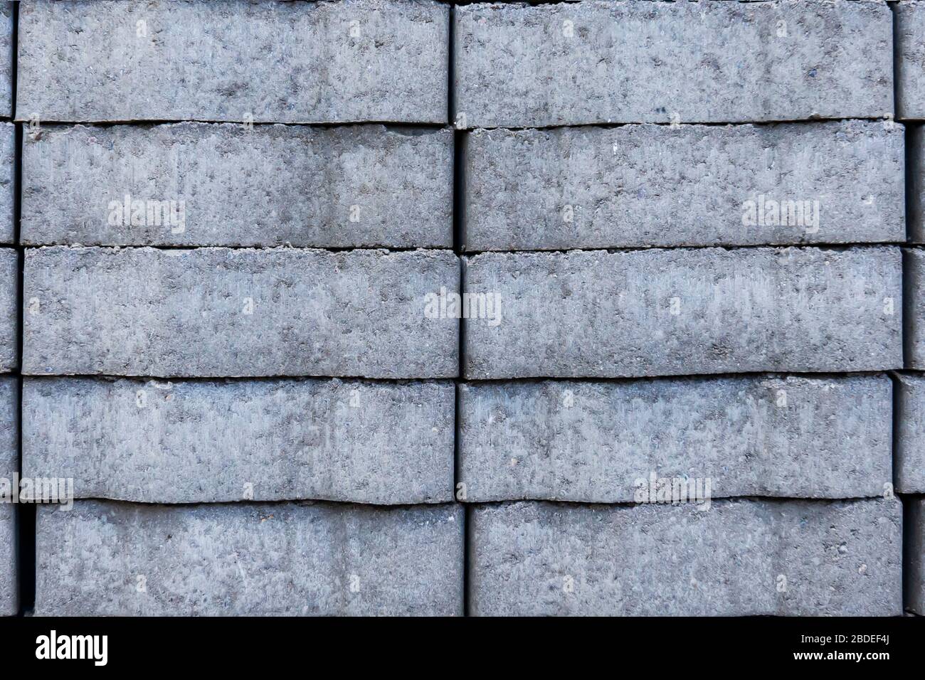 grey textured background, border stone, laid in a stack, side view ...